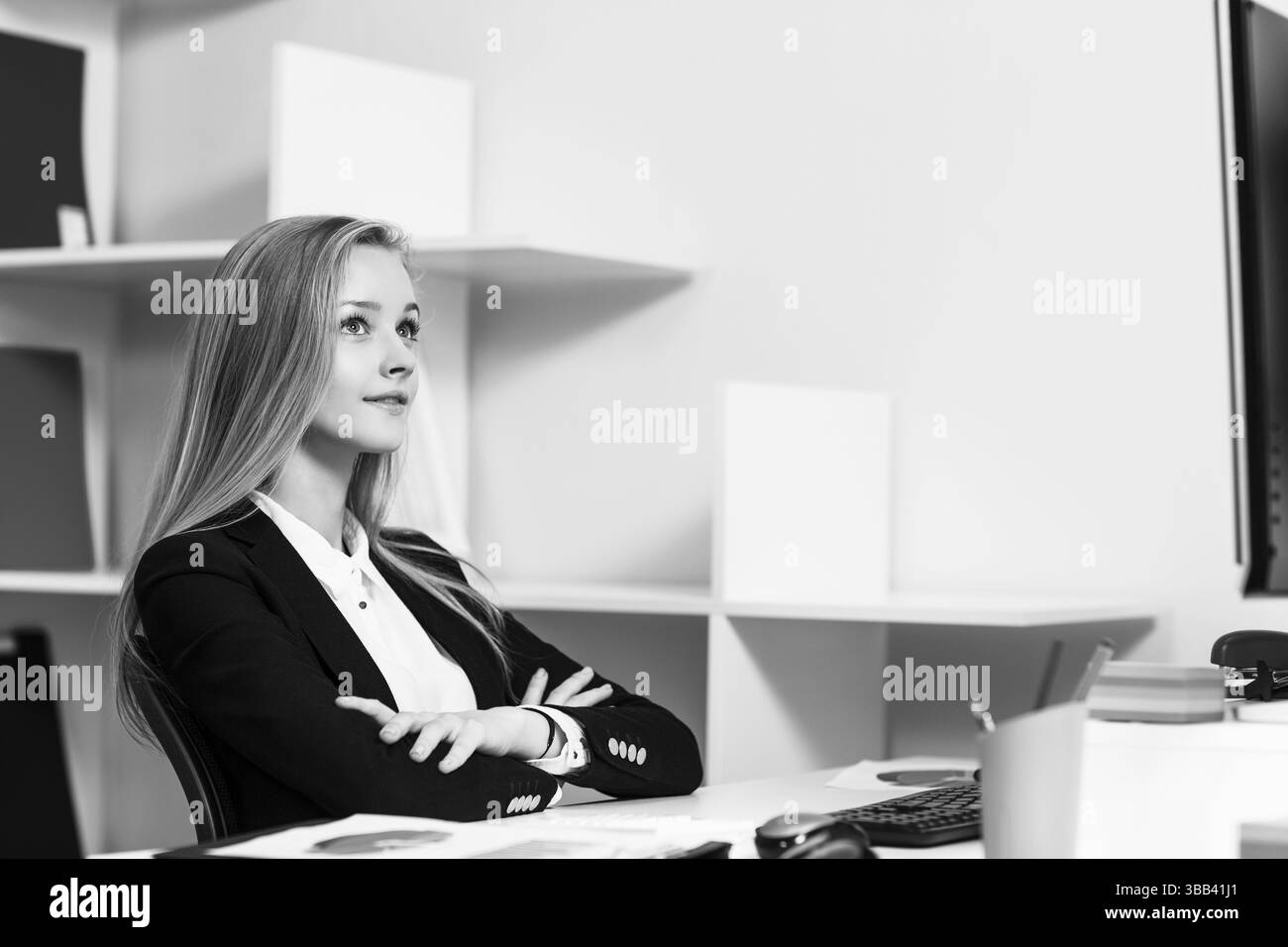 Young pretty business woman sitting at the desk with computer in blue ...
