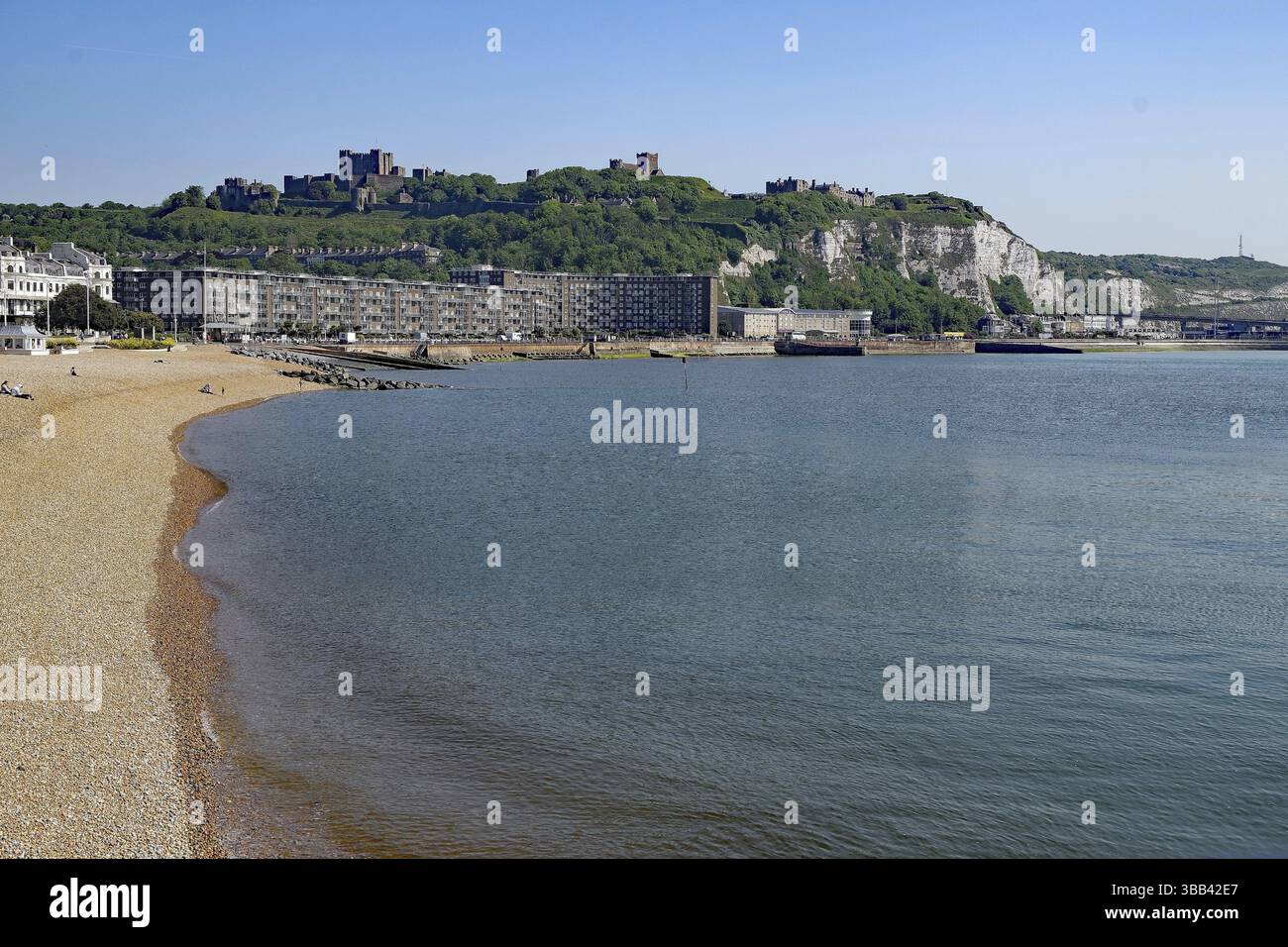 Coastal view with sandy beach, buildings and a castle on the hill ...