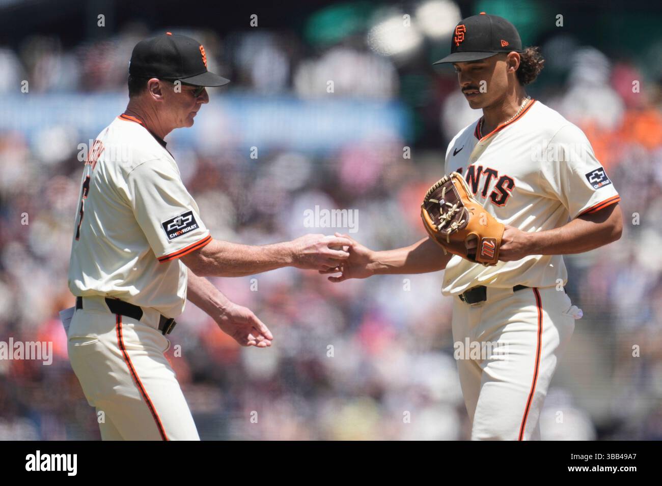 San Francisco Giants pitcher Jordan Hicks, right, hands the ball to ...