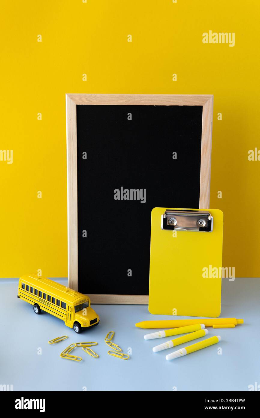 Yellow school theme with clipboard blackboard markers paper clips and ...