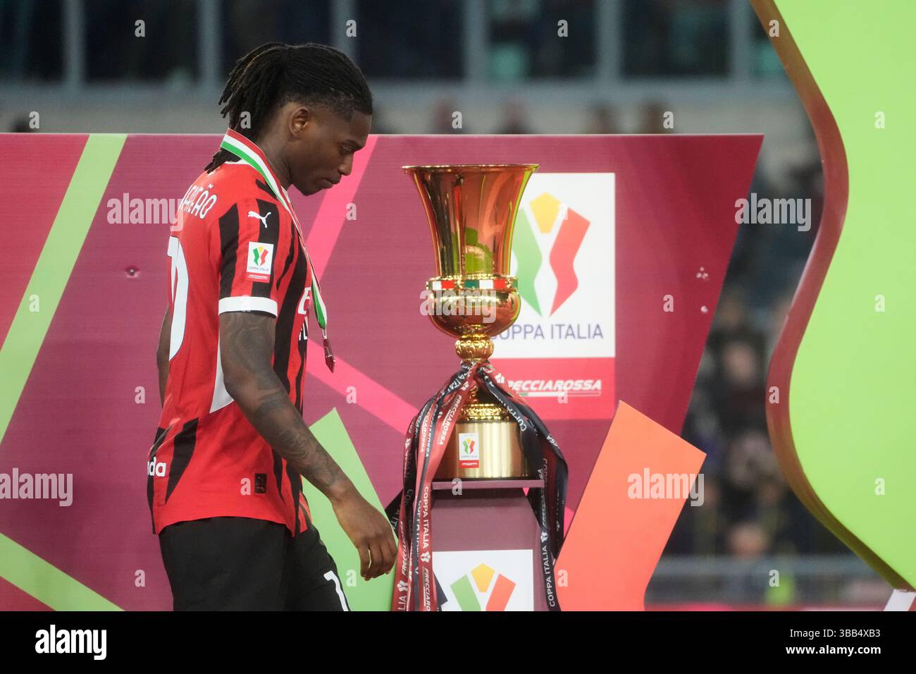 AC Milan's Rafael Leao passes the trophy during the medal ceremony ...