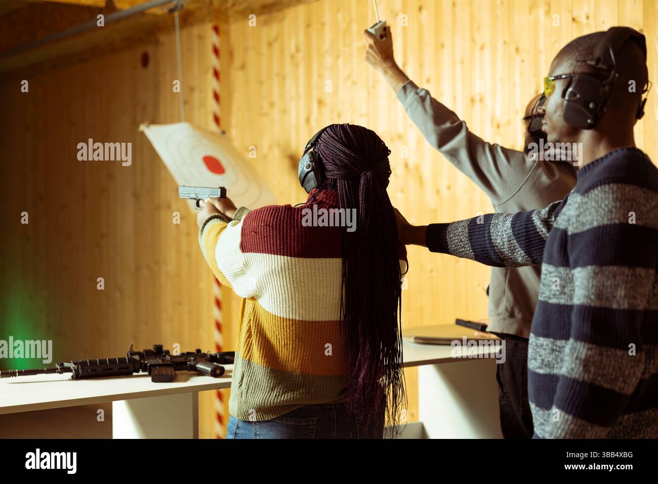 Shooting gallery employee telling woman how to properly use arm holding ...