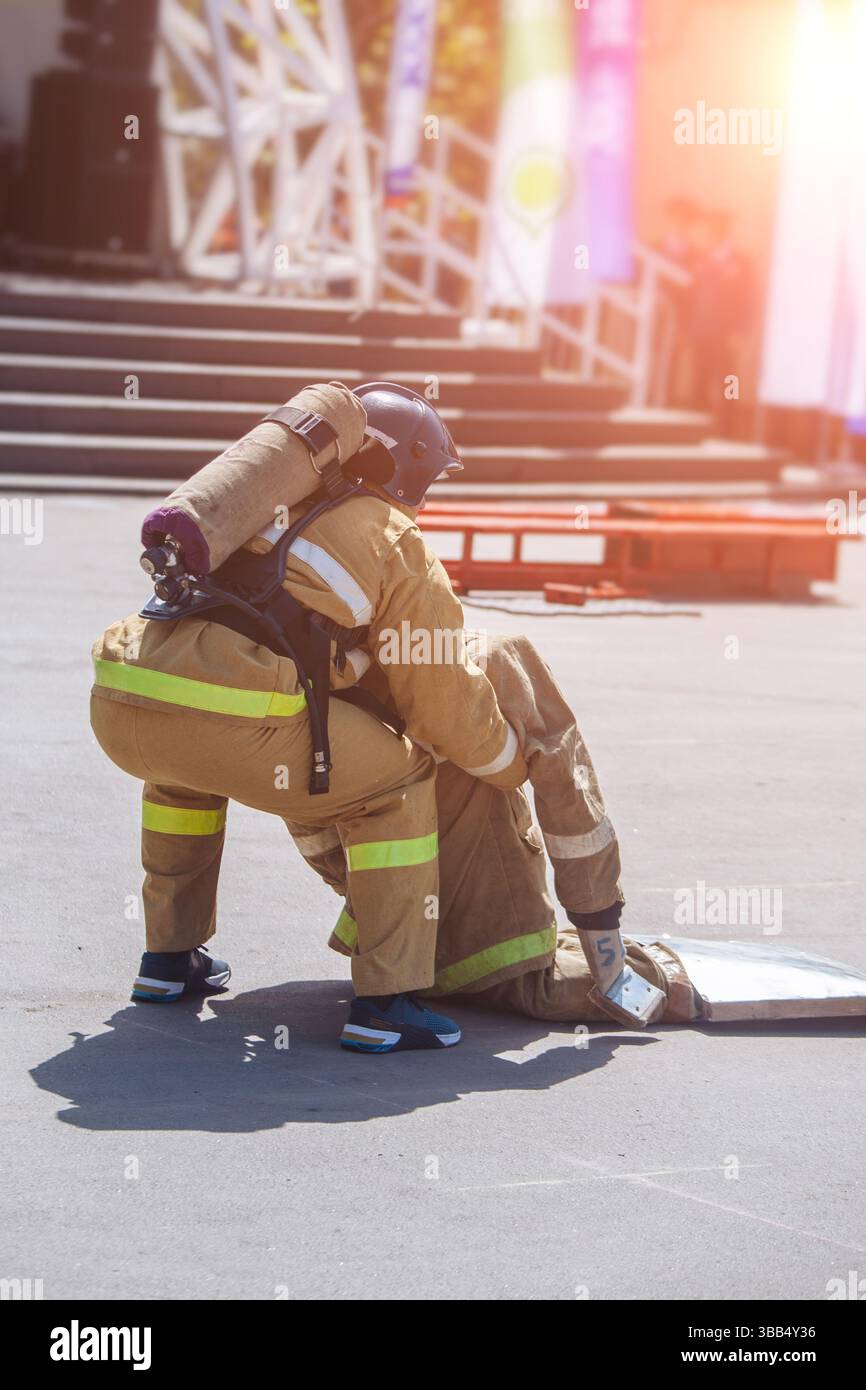 Fireman in uniform is dragging a mannequin on training Stock Photo - Alamy
