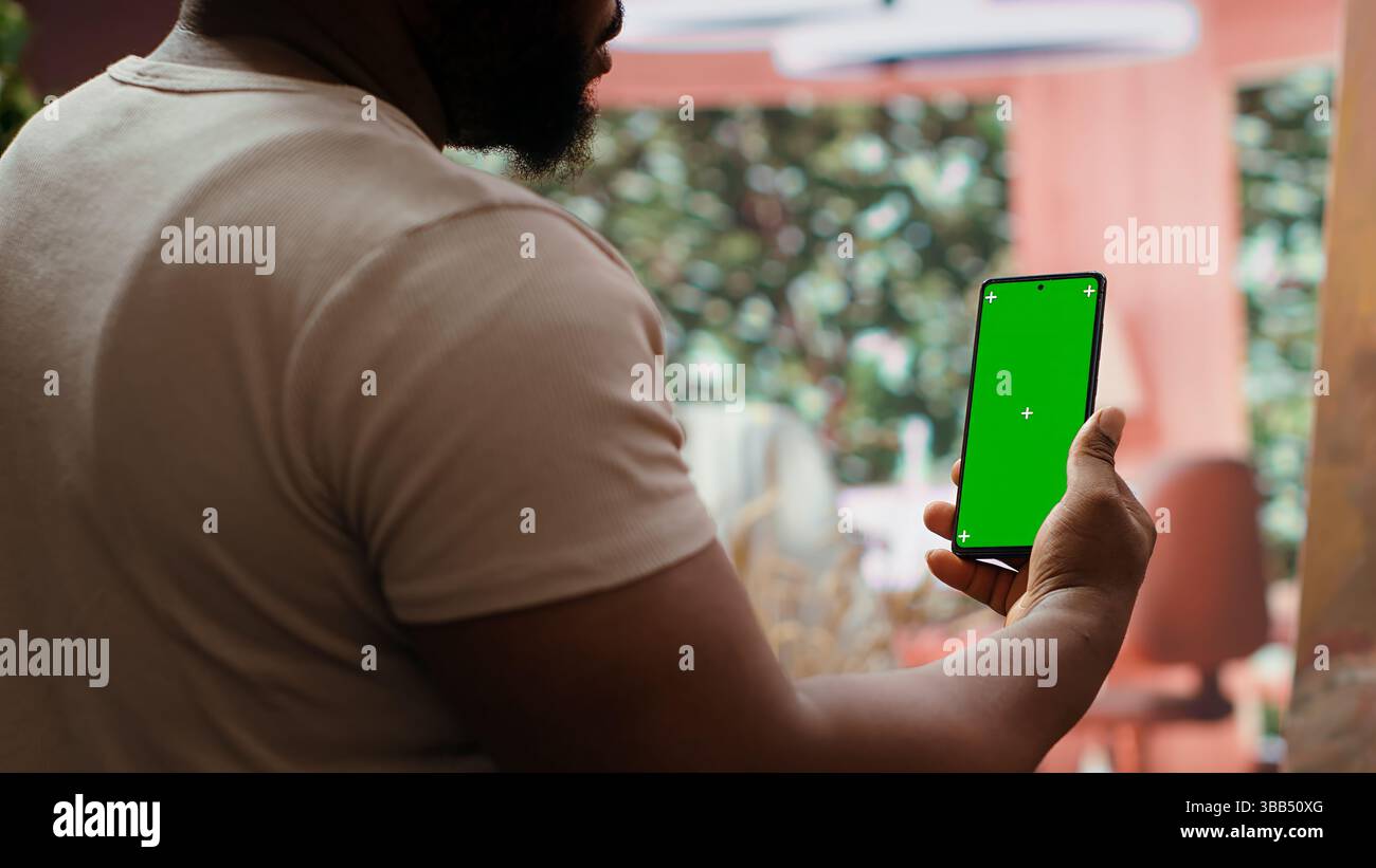 Young artist looking at isolated chroma key display in his painting ...