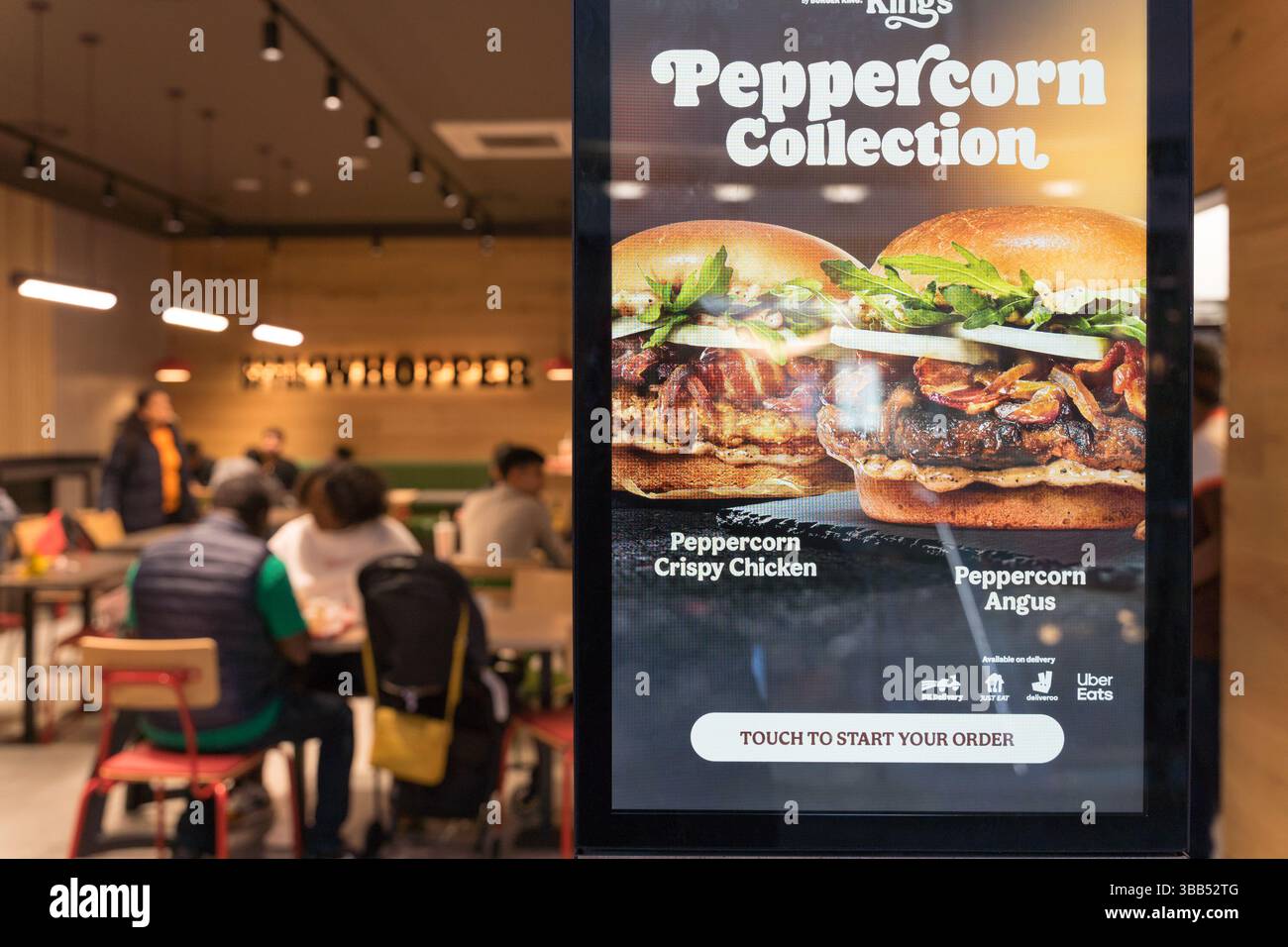 Eat-In Customers Enjoy Meals at Burger King Diner Behind Large LED Menu ...