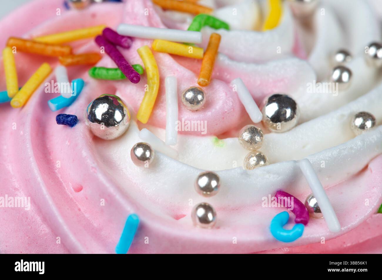 White and pink whipped cream with sprinkles Stock Photo - Alamy