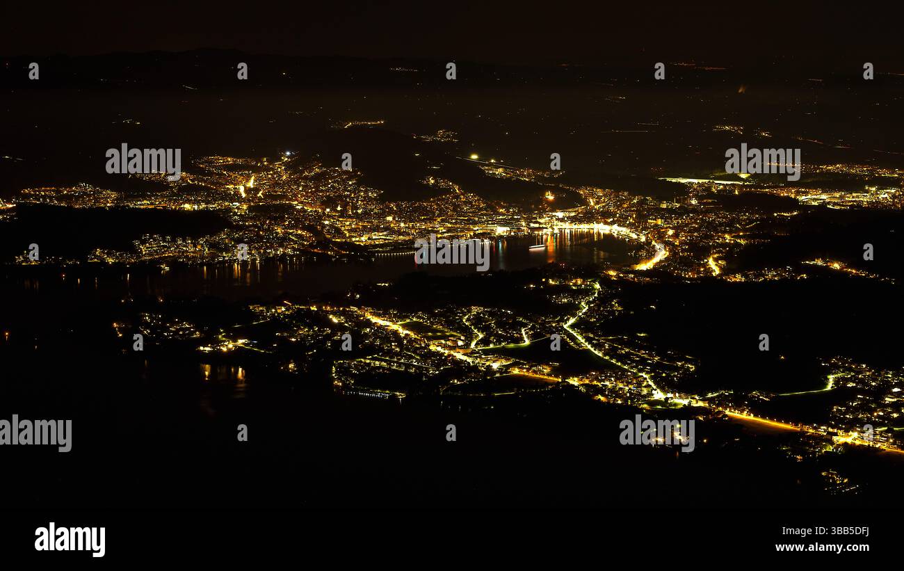 A stunning view of a city at night, with bright lights reflecting on ...