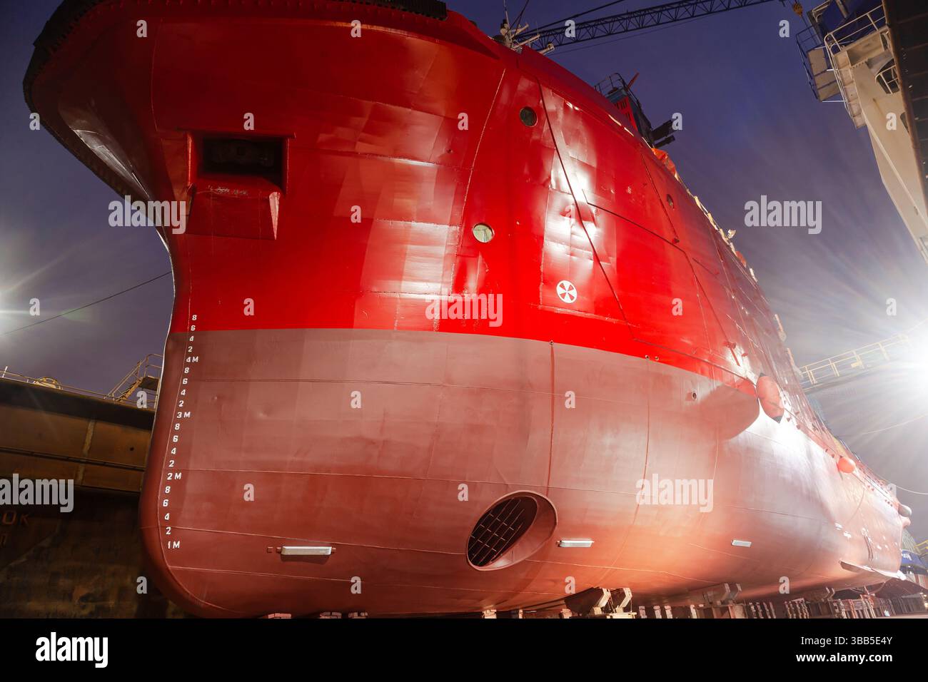 A ship standing in a dry dock at night under the light of lanterns Stock Photo - Alamy
