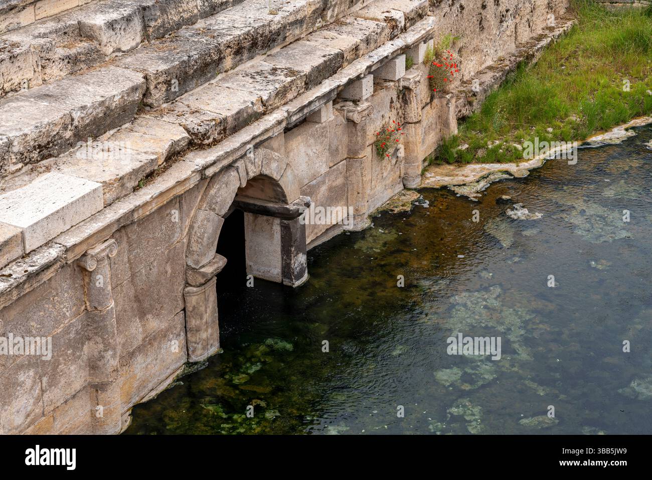 The Ploutonion in Hierapolis has a stone structure with arches and a ...