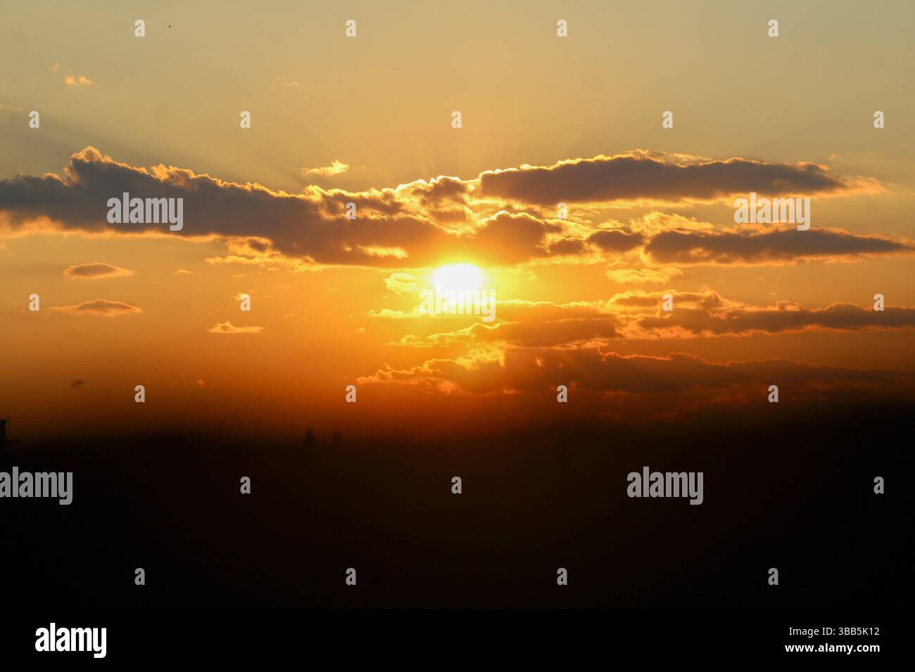 A breathtaking sunset with golden rays piercing through layered clouds ...