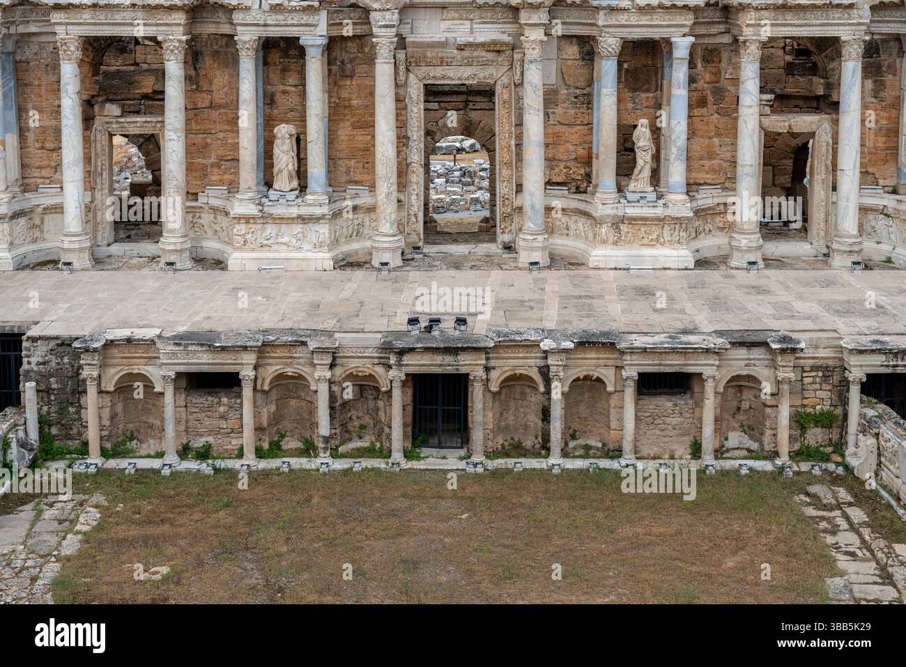 A richly decorated marble stage wall with columns and sculpted figures ...