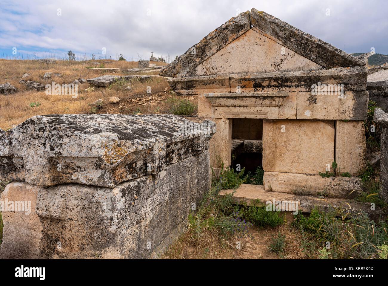 A monumental stone tomb with a gabled roof and open doorway marks the ...