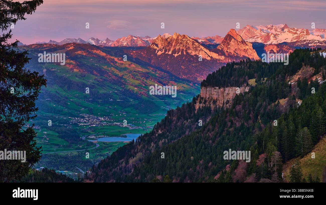 Dramatic mountain peaks glow in warm sunset tones as shadows lengthen ...