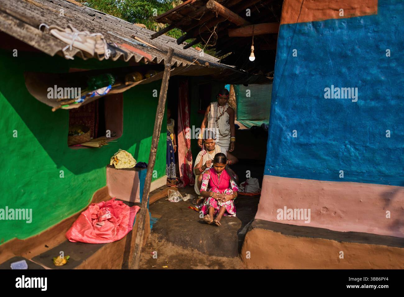 A woman, from the Durua Indigenous community, combs her daughter's hair ...