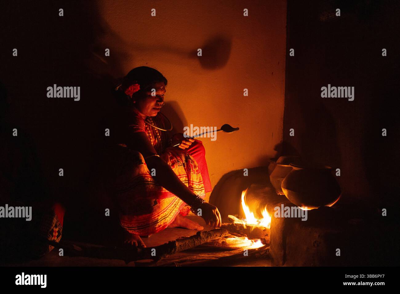 Sunita Muduli, 34, from the Paroja Indigenous community cooks on a clay oven in Putpondi village ...