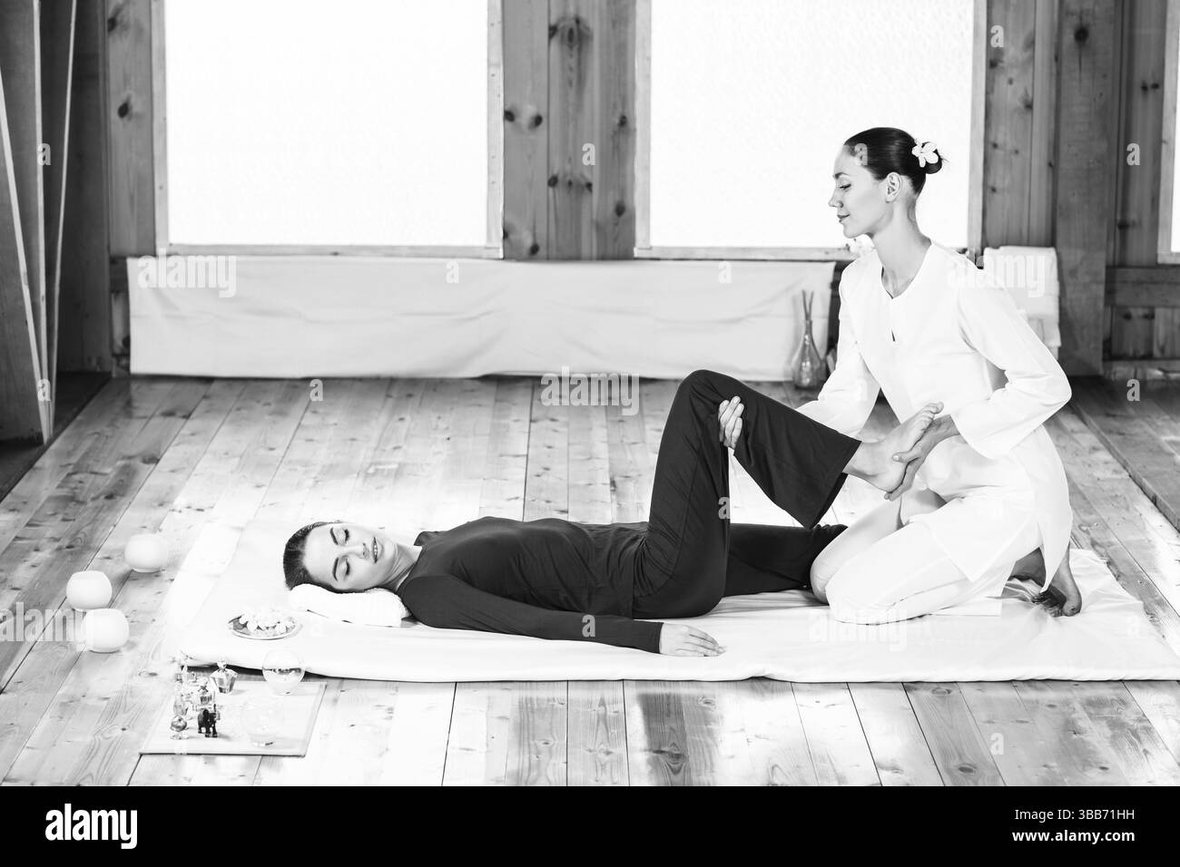 Young woman getting traditional thai stretching massage by therapist Stock Photo - Alamy