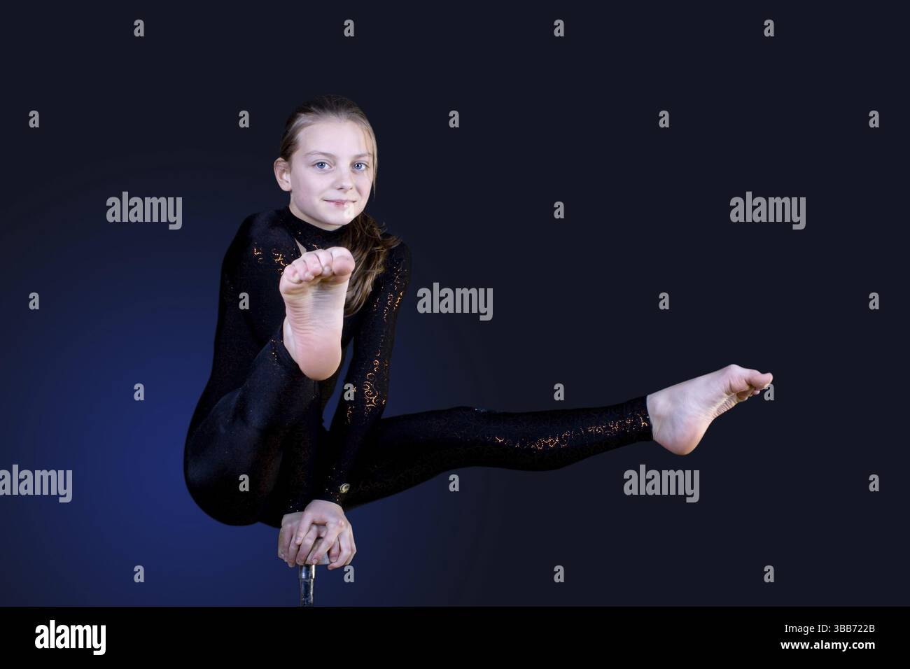 Acrobatic and gymnastic poses in front of black background Stock Photo ...