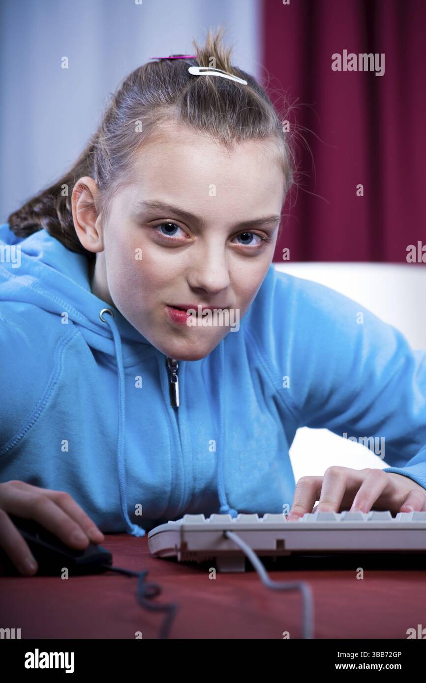 Girl with a mouse and keyboard playing computer game Stock Photo - Alamy