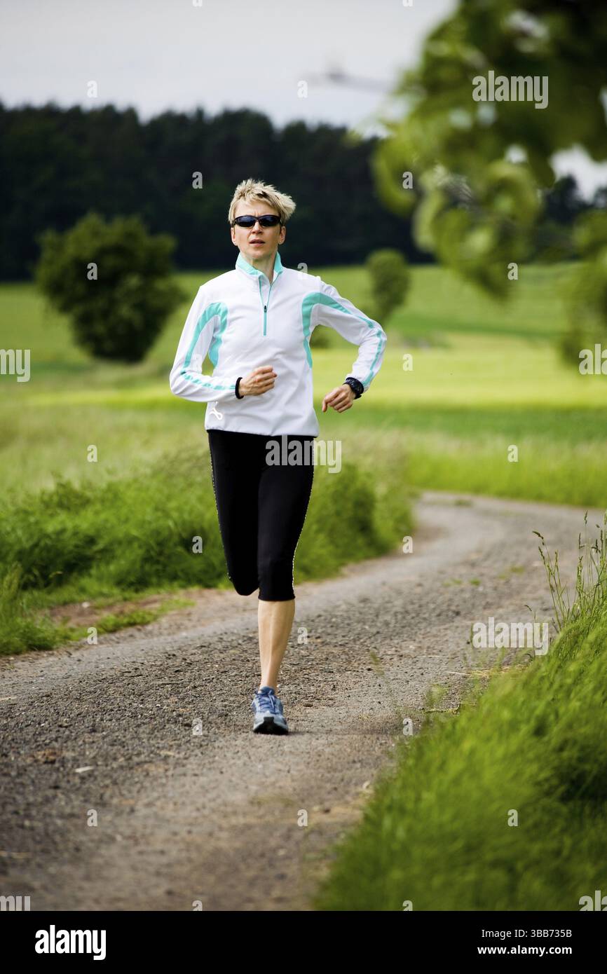 A woman jogging in front of cross country Stock Photo - Alamy