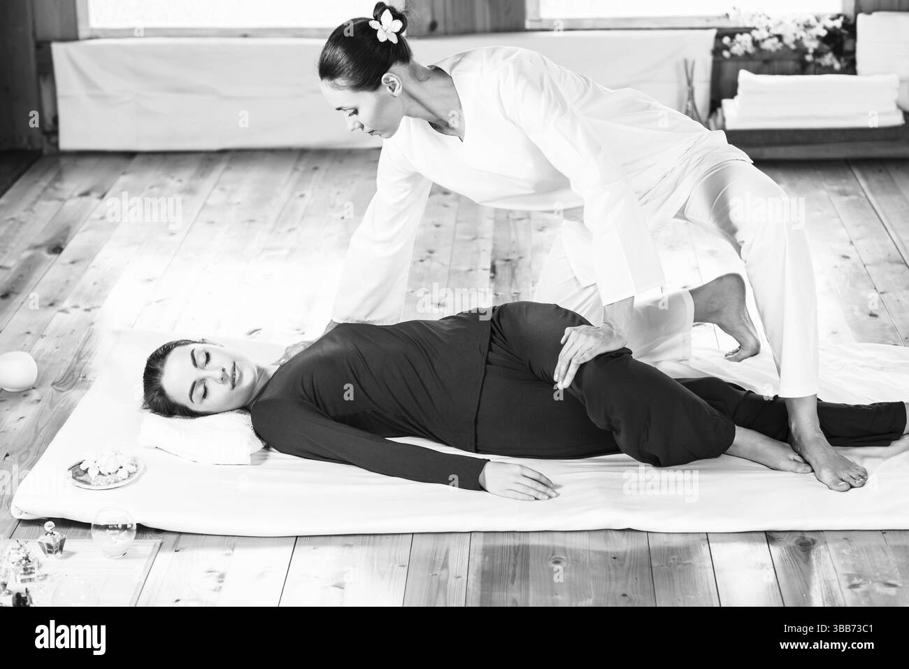 Young woman getting traditional thai stretching massage by therapist Stock Photo - Alamy