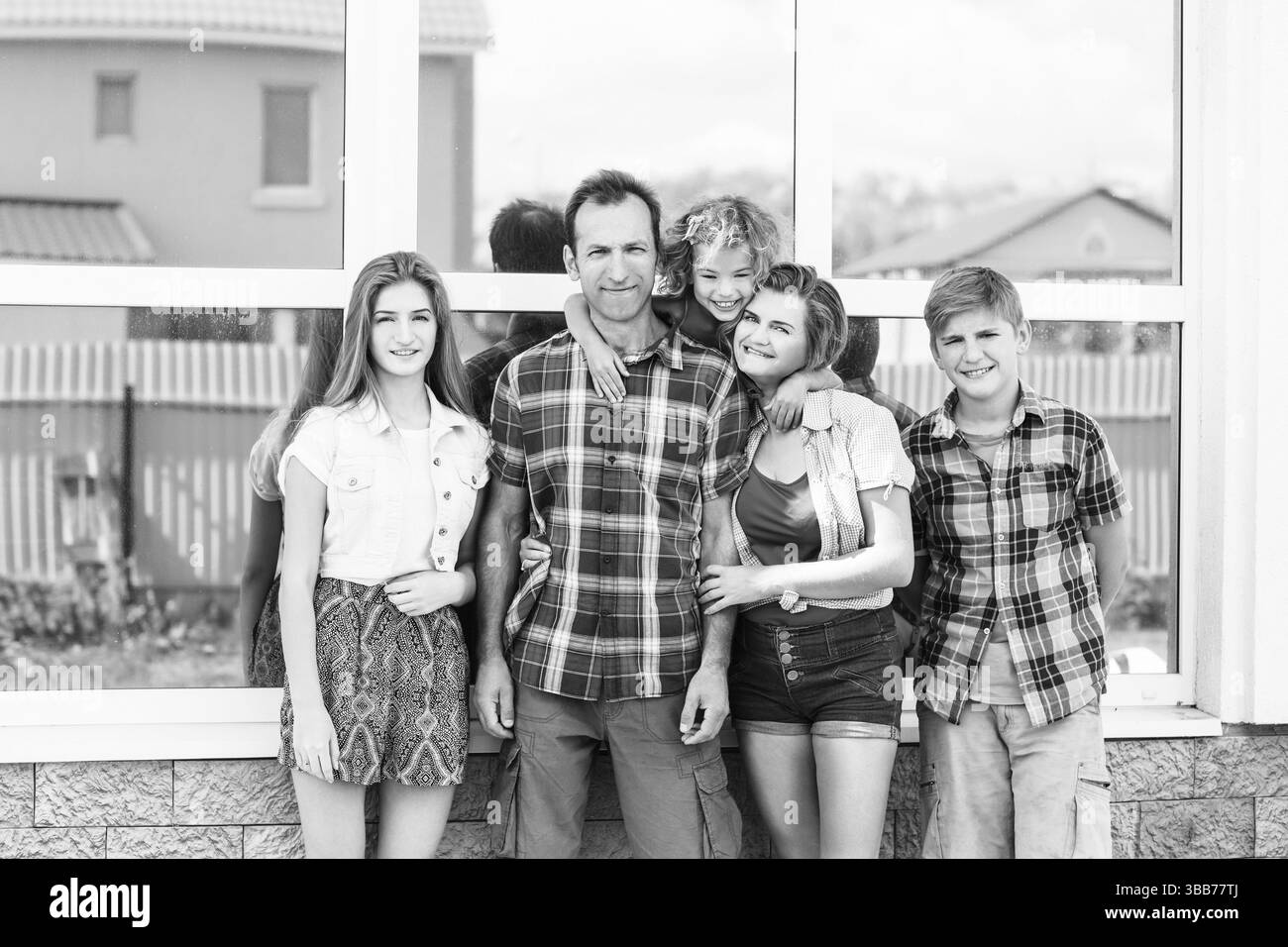 Big happy family stands beside their house Stock Photo - Alamy