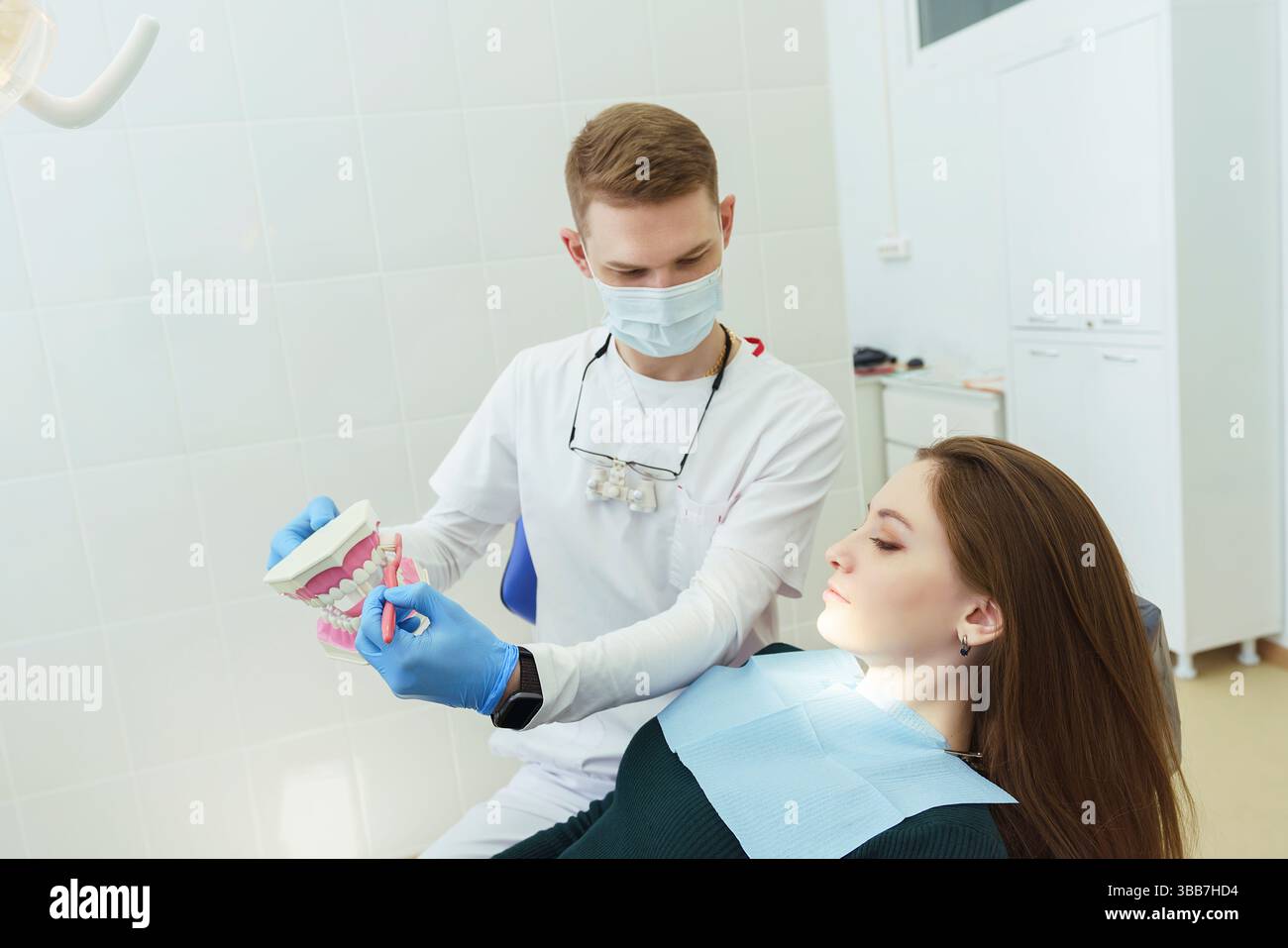 the dentist teaches the rules of cleaning and hygiene of the oral ...