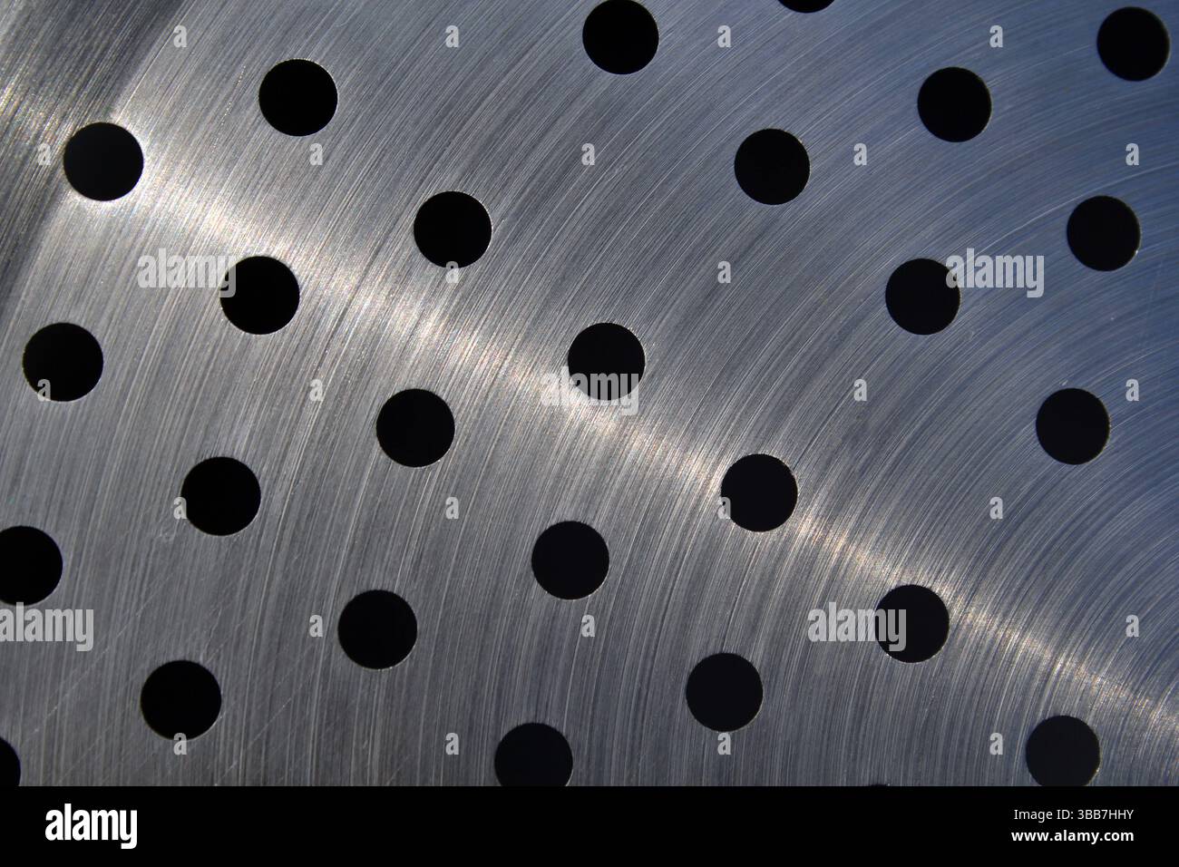 Metallic surface with a pattern of circular holes abstract textured ...