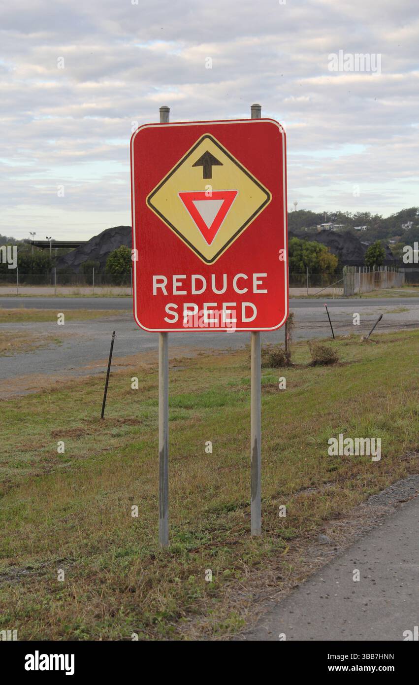 Reduce Speed sign by the side of a road Stock Photo - Alamy