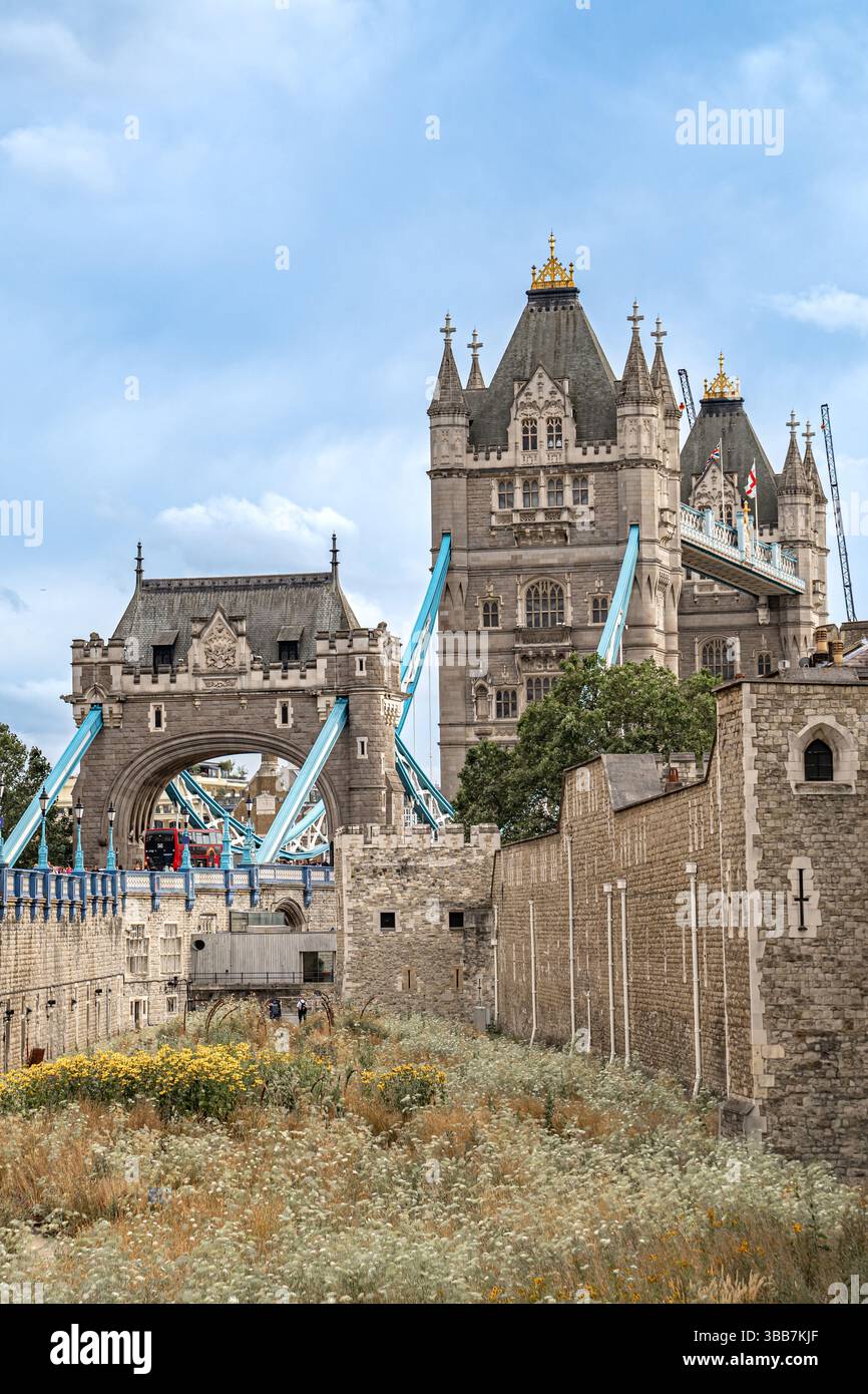 Tower Bridge rises behind the weathered stone walls of the Tower of ...