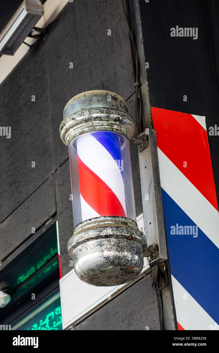 A barber pole featuring red, white, and blue stripes that twirl around ...