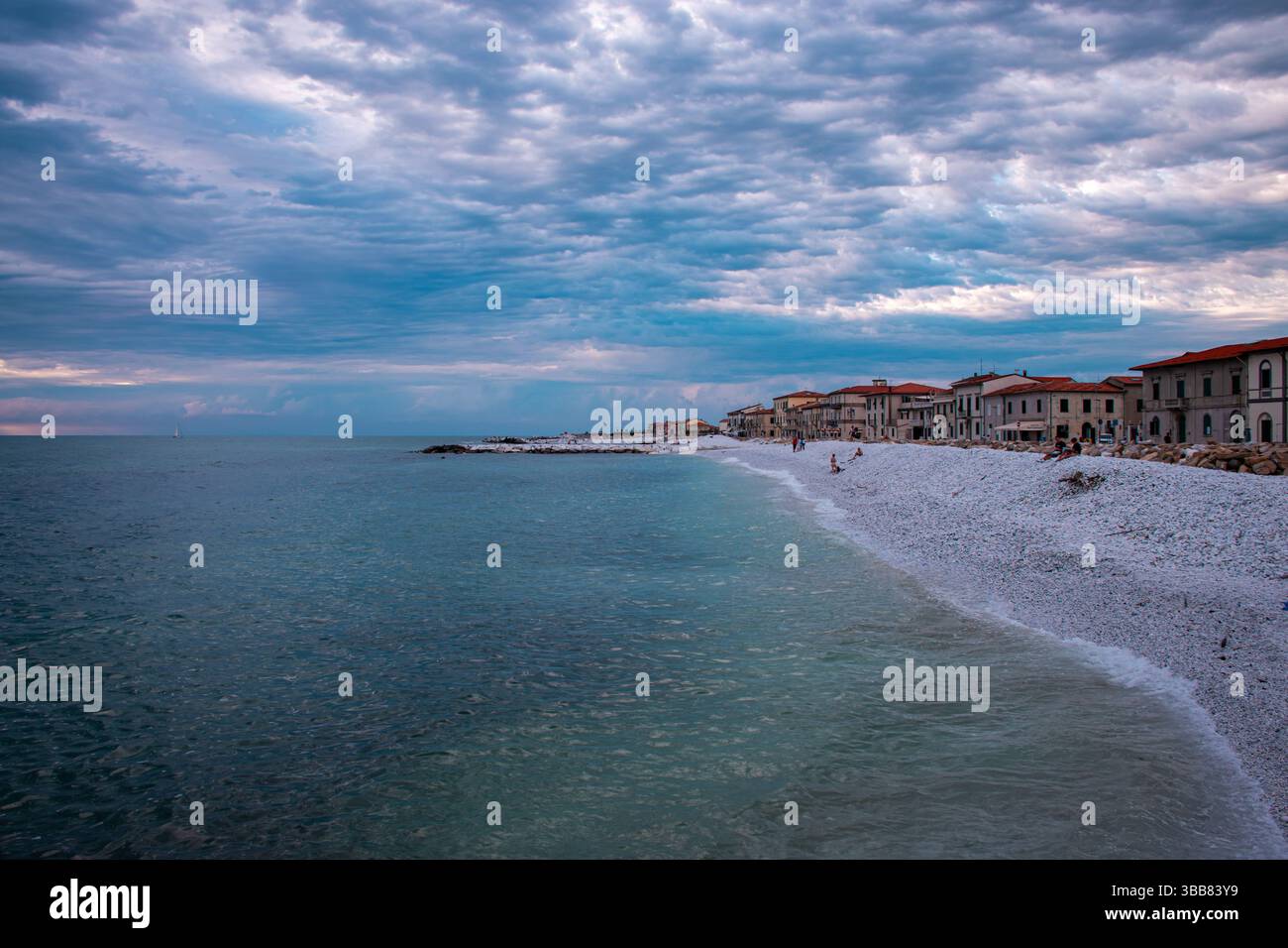 Spring view of the sea at Marina di Pisa under a cloudy sunset sky ...