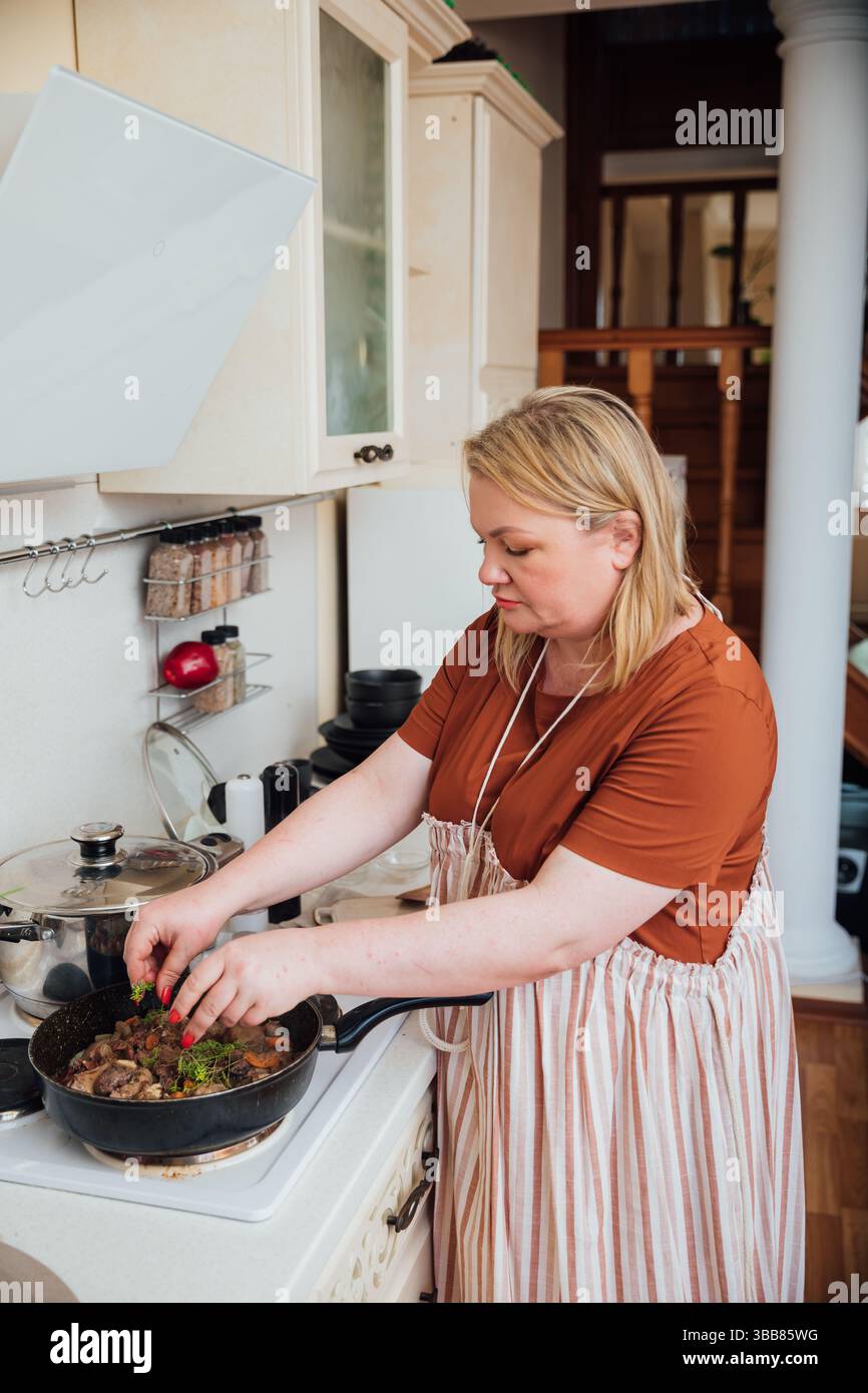 Blonde Cook Housewife Preparing Meals In Kitchen For Lunch Stock Photo - Alamy