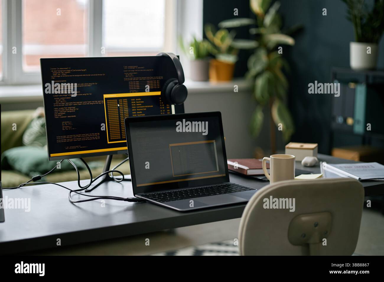 Modern workspace featuring dual monitor setup with programming code on screens. Workspace ...