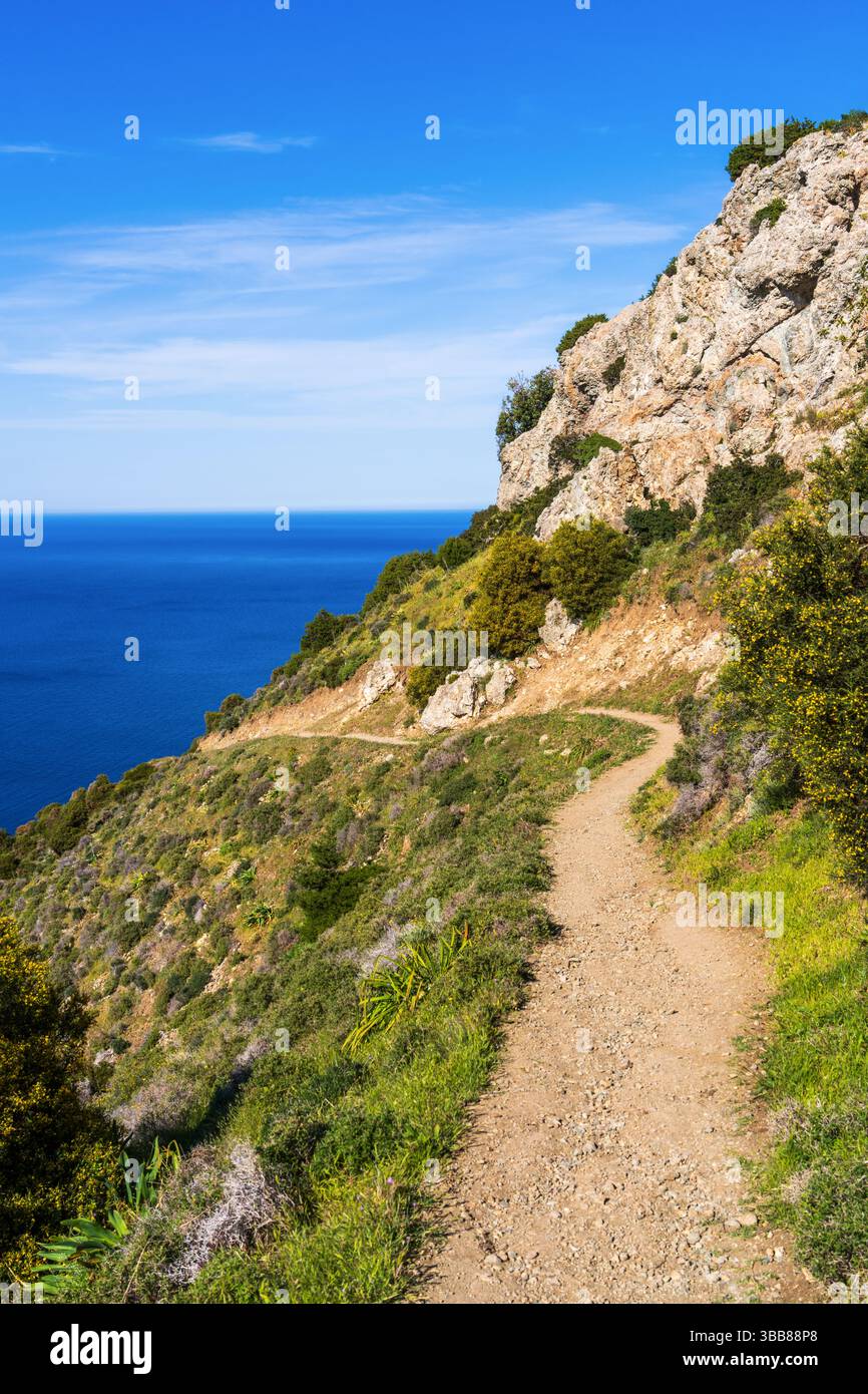 Ppicturesque hiking trail winding through mountains along the stunning coastline of Cyprus. Path ...