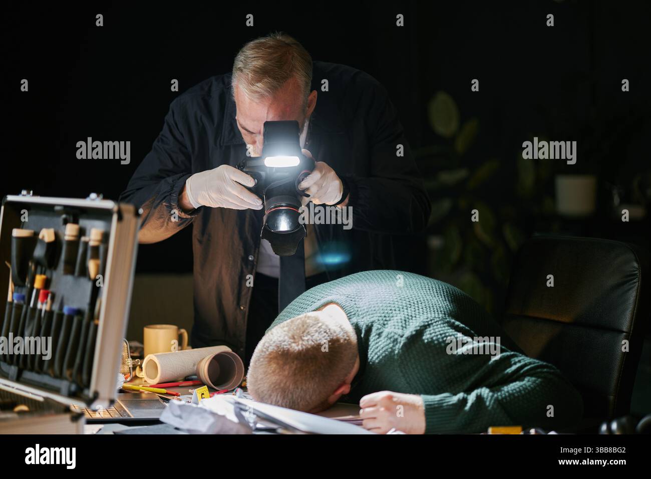 Photographer taking photo of stressed man collapsed on desk at office ...
