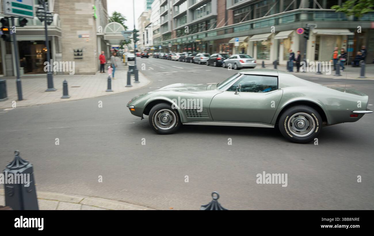 Grey Corvette C3 driving on city street. Side view of 1970s Chevy ...