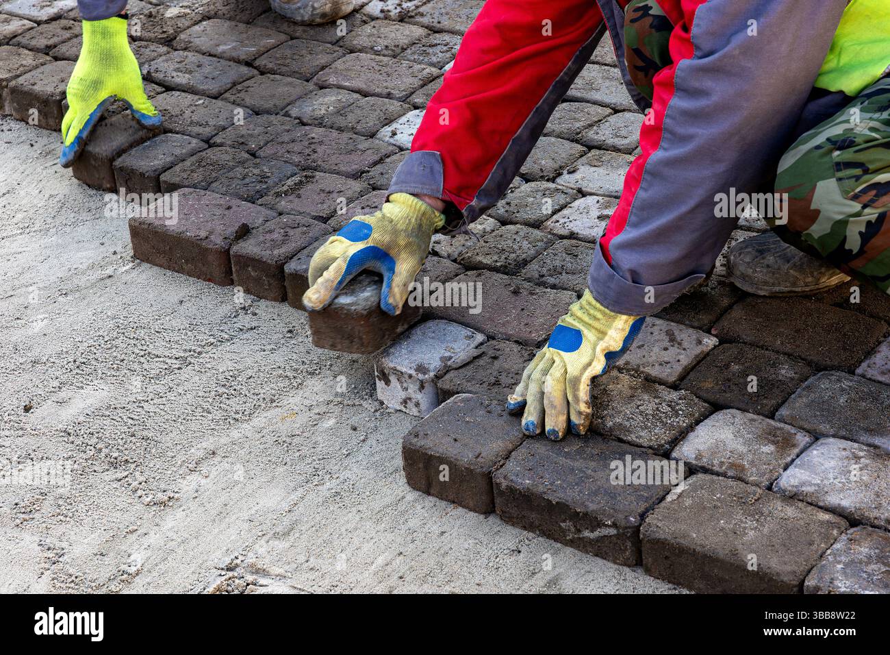 Construction Workers Laying Cobblestone Pavement by Hand. Workers in ...