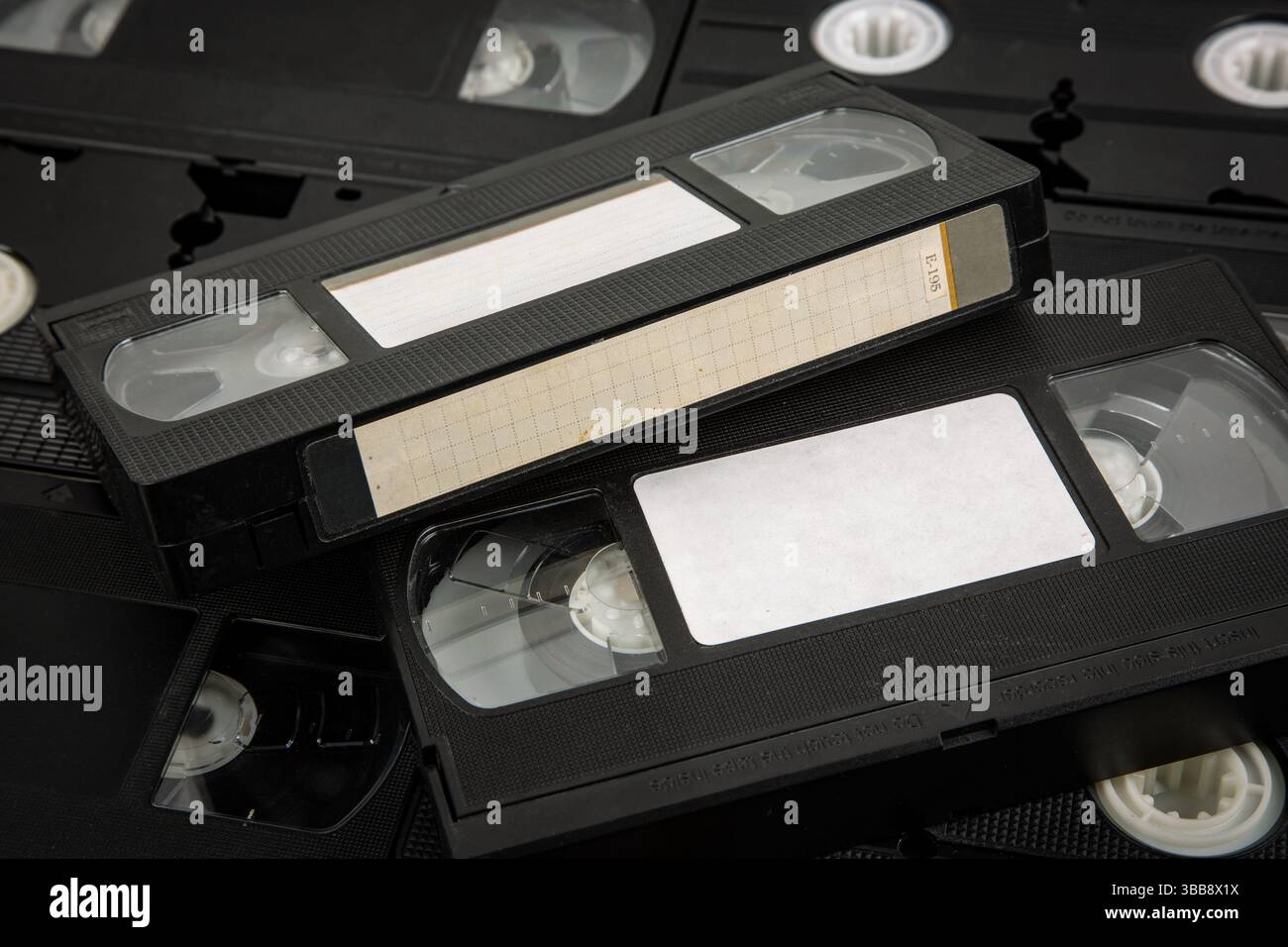 Close-up of vintage VHS video tapes with blank labels, stacked together ...