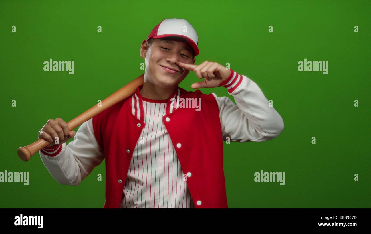 Young chinese man in baseball uniform holding bat and pointing at his ...