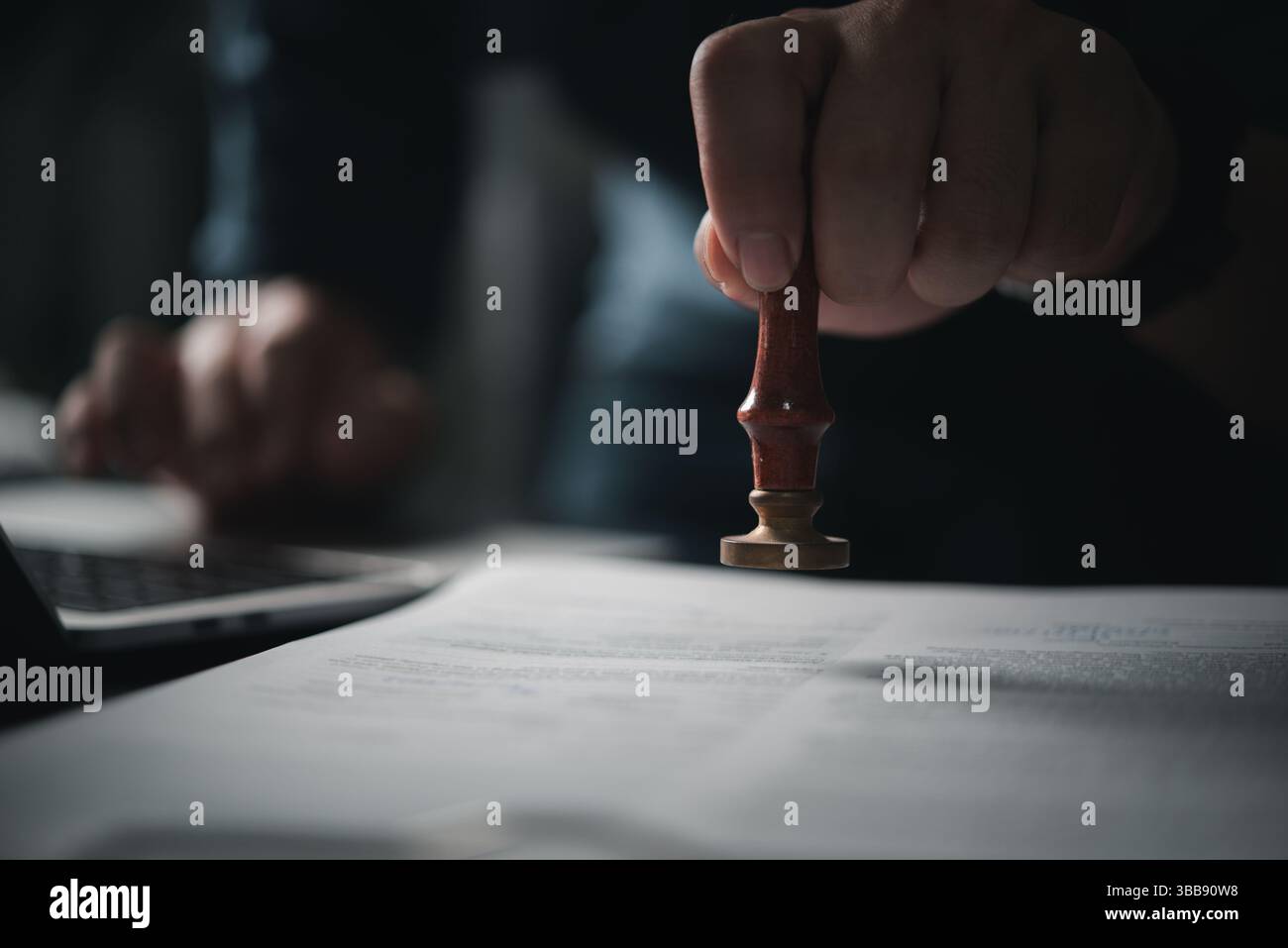 Person using a rubber stamp a document, approval, certification, or ...