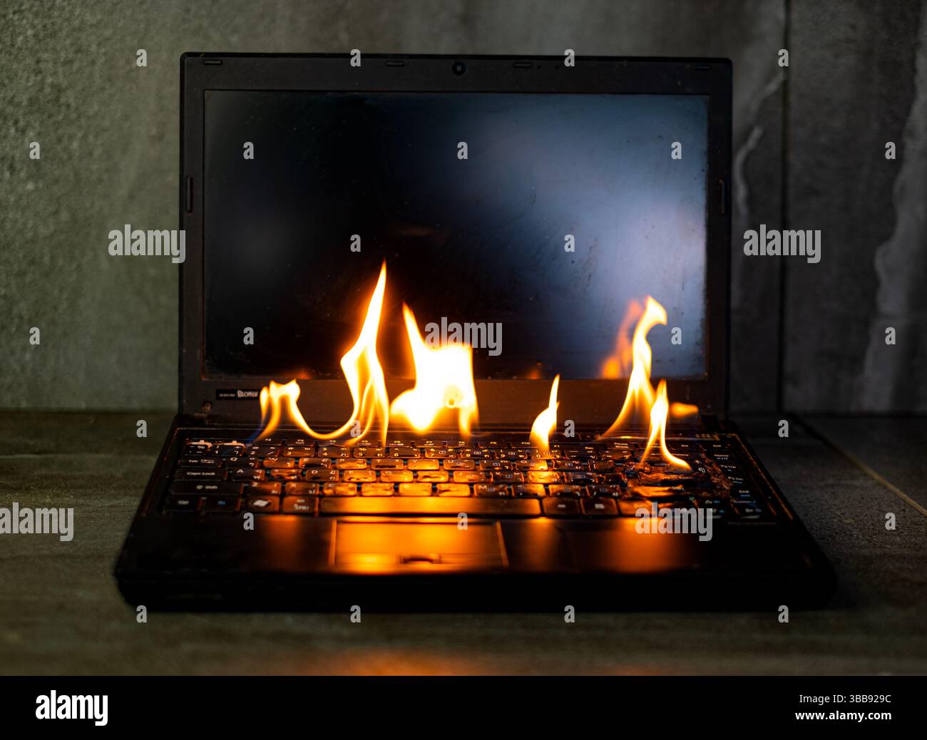 The computer laptop is burning with flames Stock Photo - Alamy
