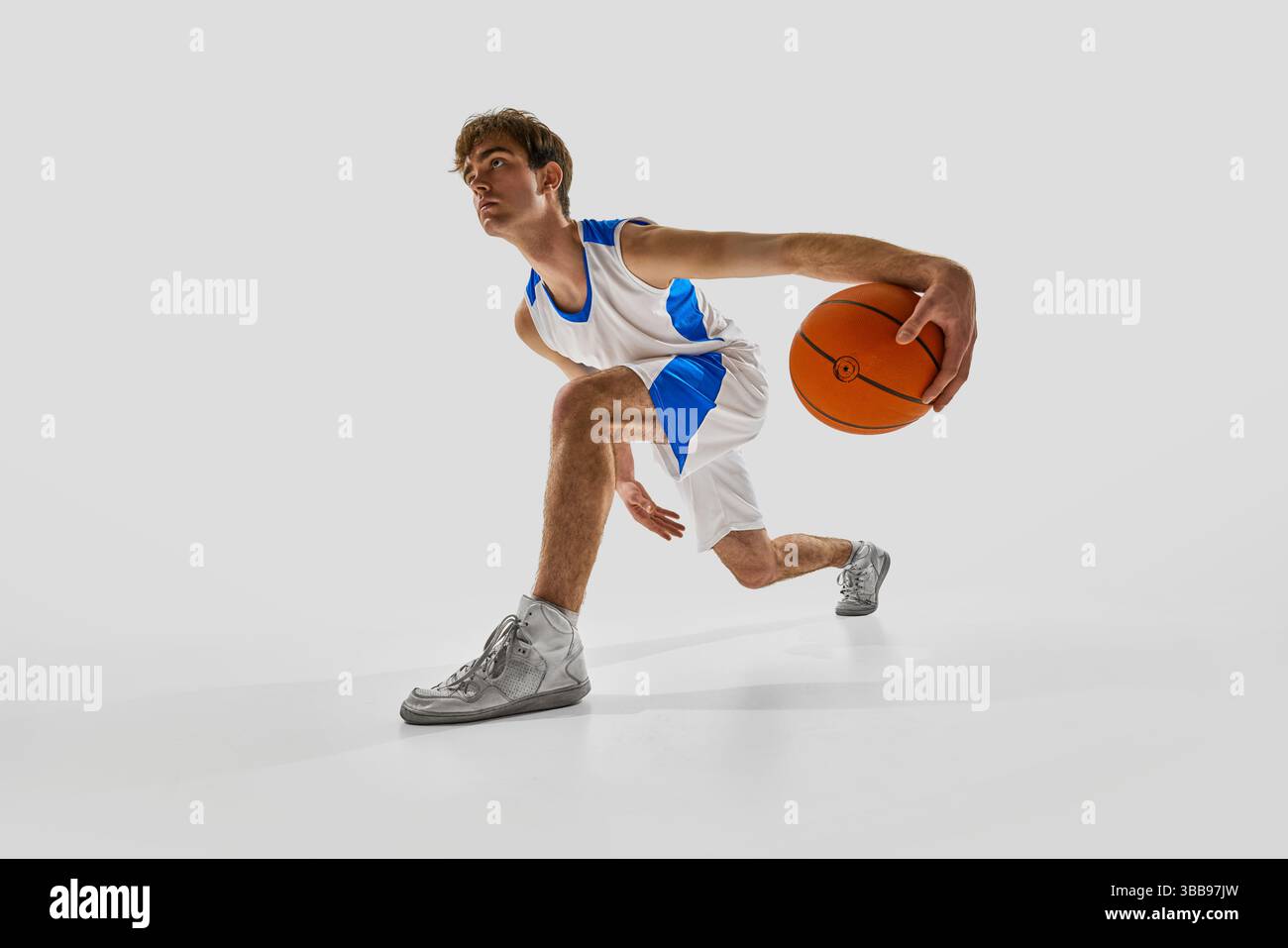Low angle photo. Basketball player moving forward, leaning into moment ...