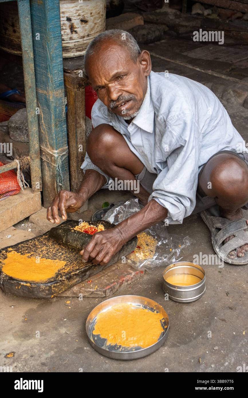 KOLKATA, WEST BENGAL, INDIA - FEBRUARY 20, 2024 a man grinding spice by ...
