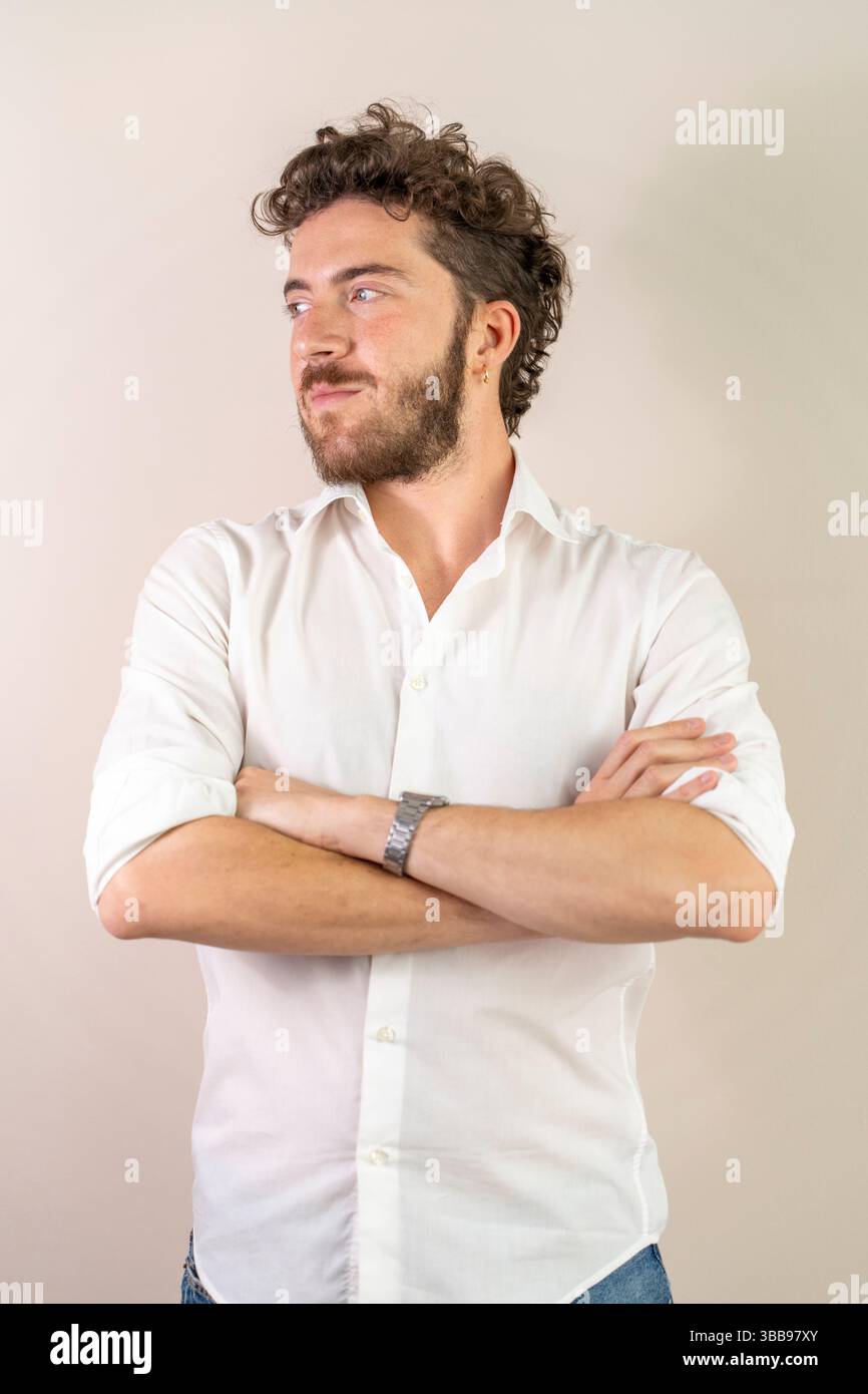 Vertical studio portrait of a millennial male in white shirt standing ...