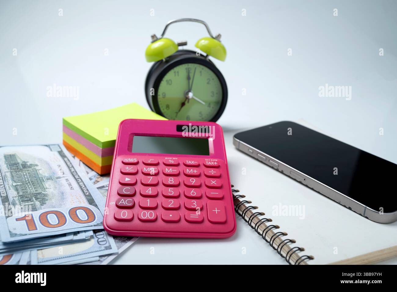 Pink calculator on stack of notes and pile of 100 dollar banknotes with ...