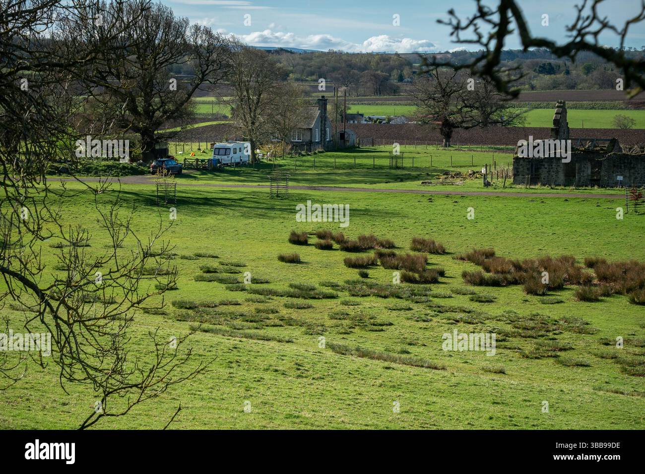A peaceful countryside view with a cottage, caravan, and green fields ...
