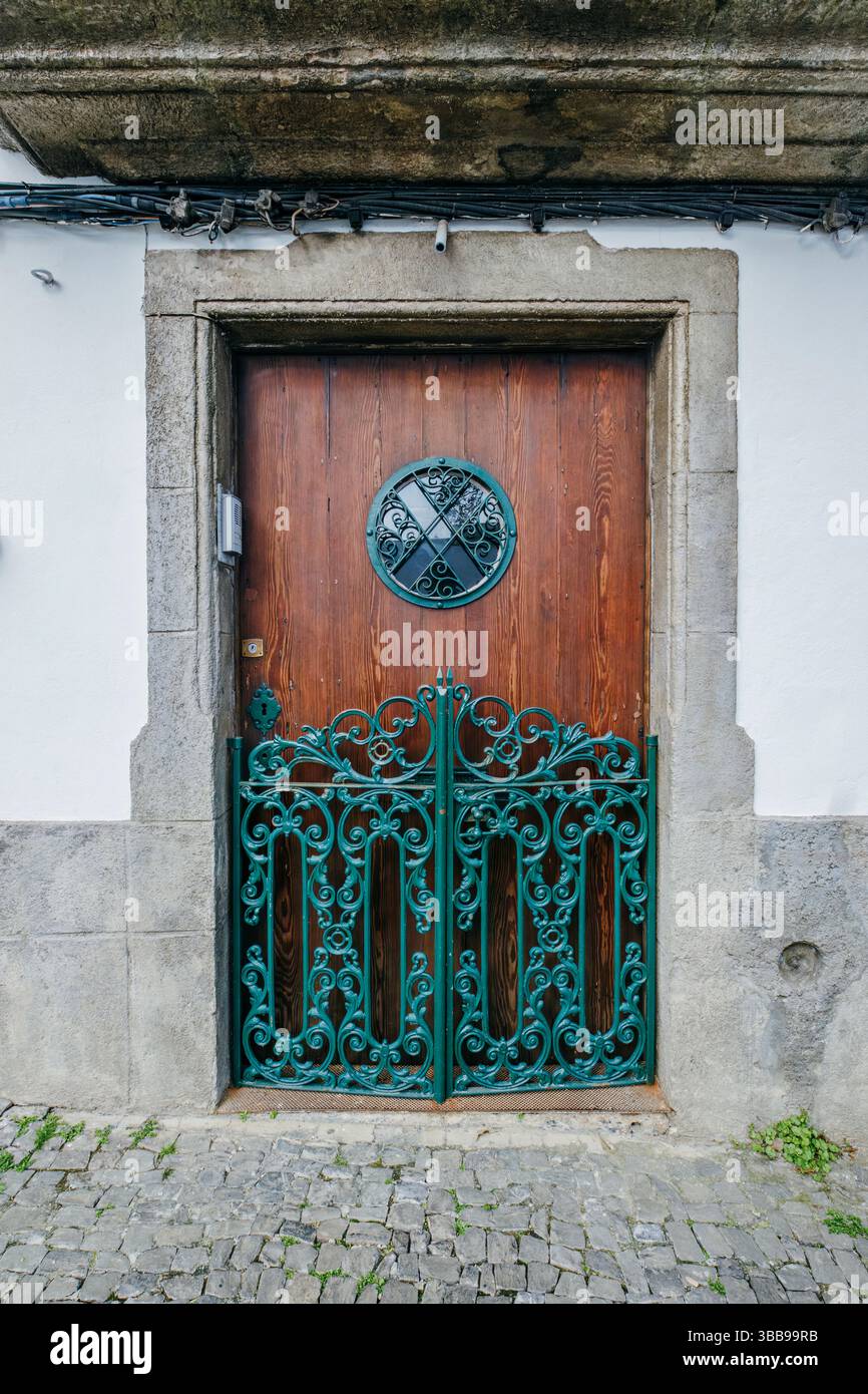 Ornate Wooden Door with Teal Iron Gate, Azores. Charming view of a rich ...