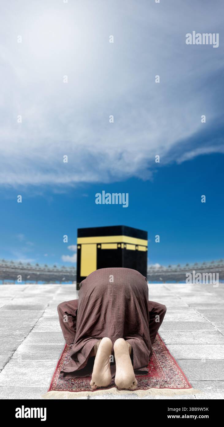 Rear view of an Indonesian southeast asian muslim man salat or praying ...