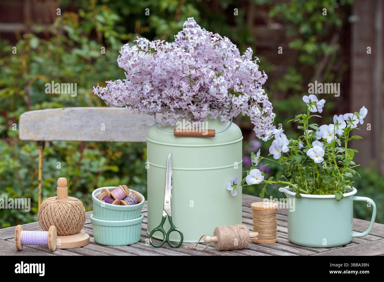 garden arrangement with bouquet of lilac, viola flower in a pot and ...