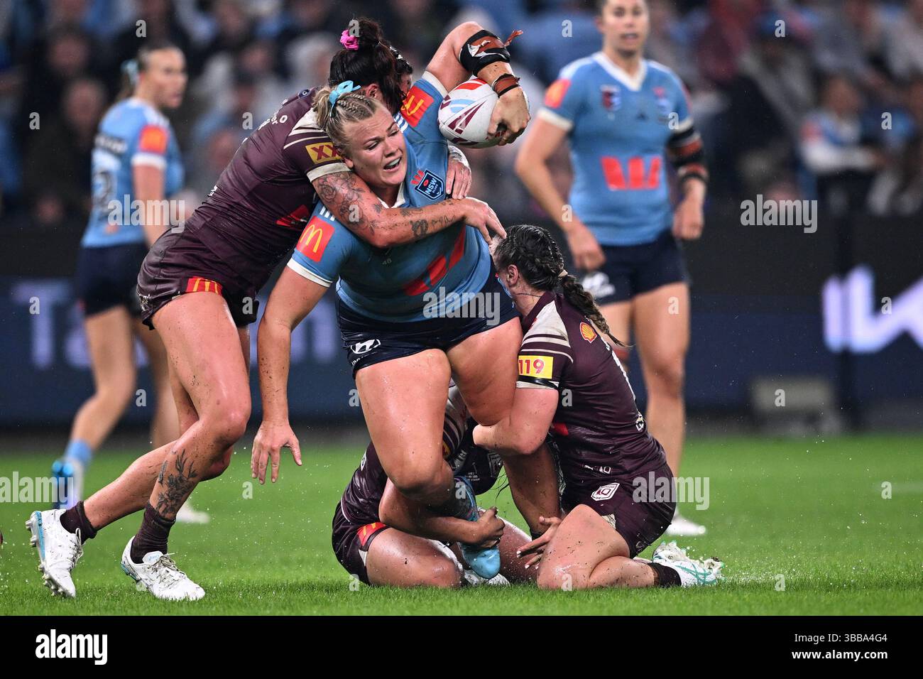 Ellie Johnston of the Blues is tackled by Lauren Brown (left) and ...
